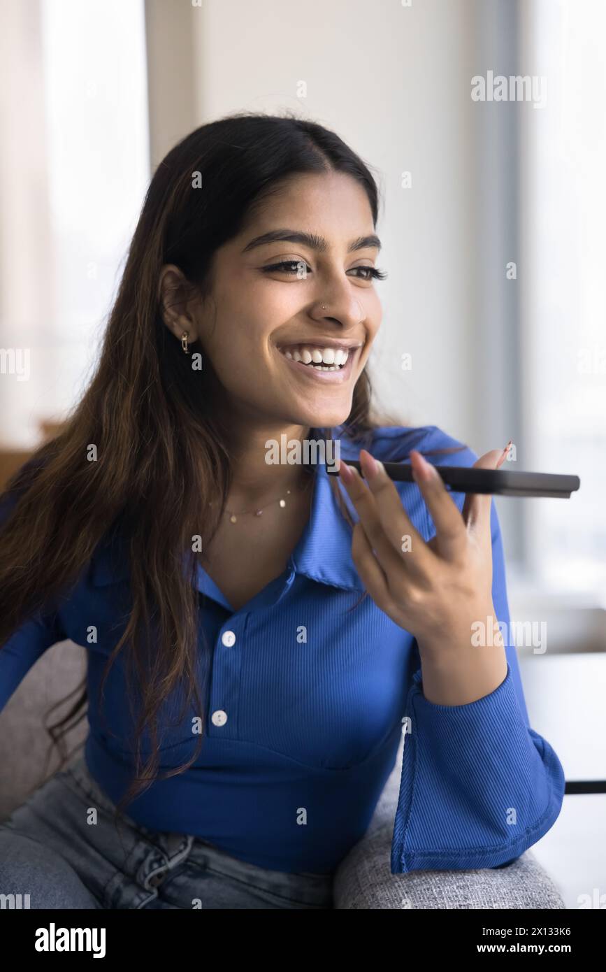 Cheerful Indian woman talking on speaker on mobile phone Stock Photo ...