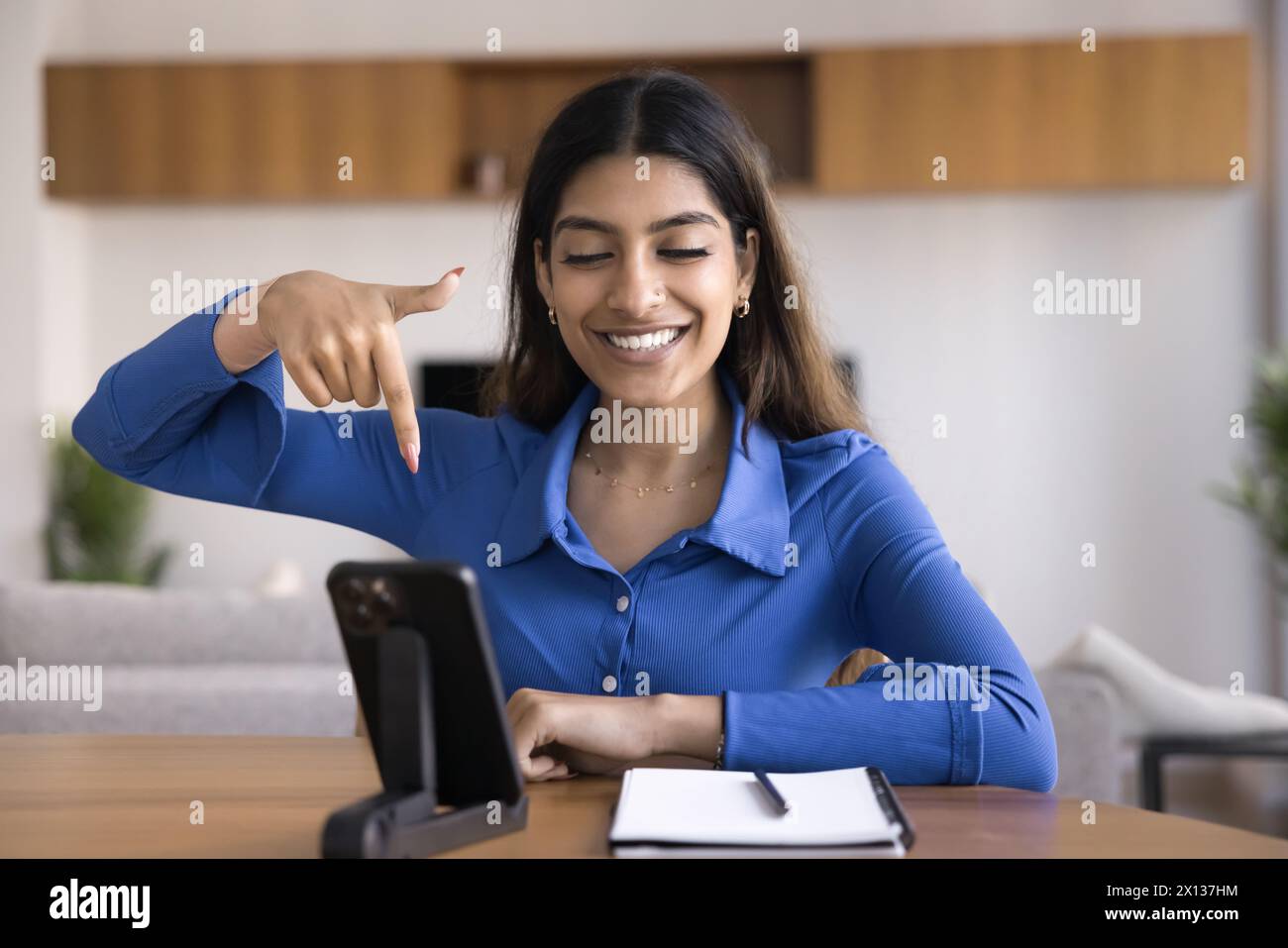 Happy attractive young Indian influencer woman shooting video review ...