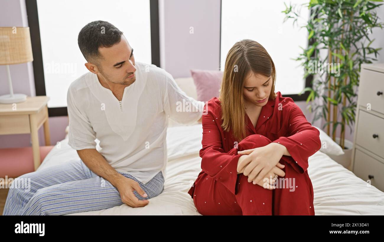 A concerned man comforts a distressed woman in a bedroom, portraying ...