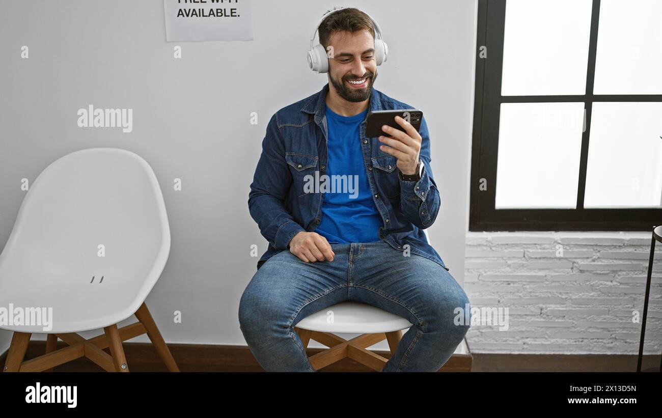 Handsome young hispanic man confidently immersed in vivid audio-visual ...