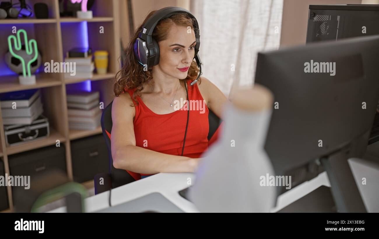 Young woman streamer playing video game using computer at gaming room ...