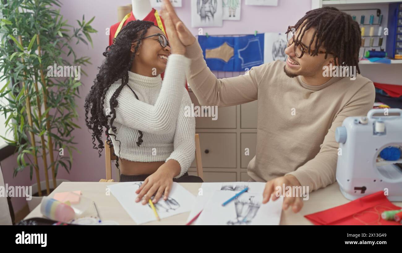 Man and woman tailors celebrating a successful design in a well ...