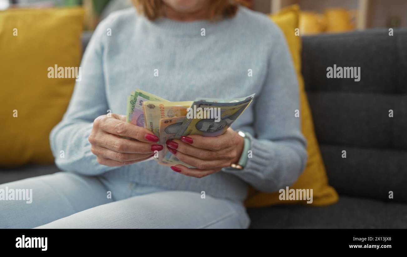 Middle-aged woman counting romanian currency indoors, illustrating ...