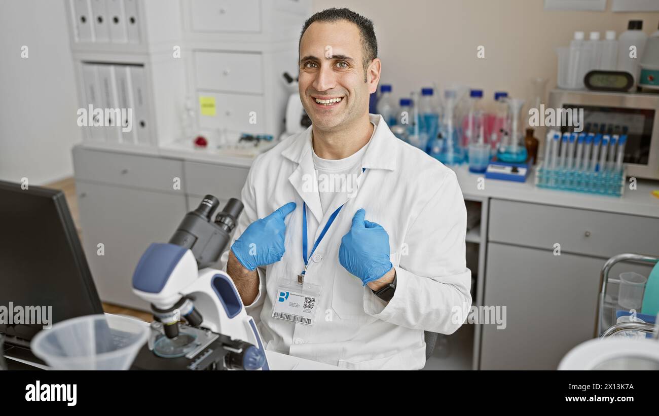 Smiling man in lab coat giving thumbs up in a laboratory with ...