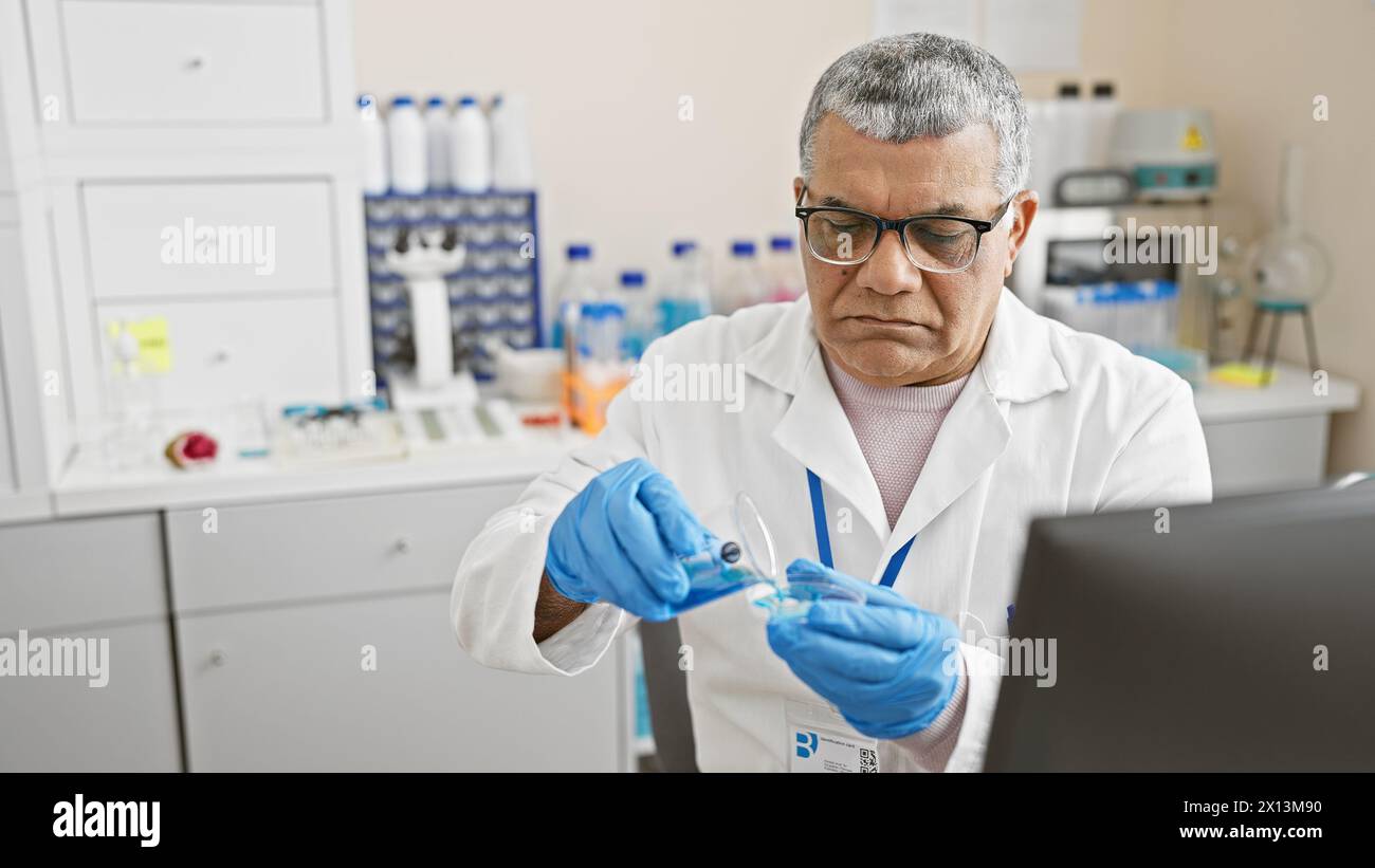 A mature man in a lab coat conducts experiments in a well-equipped ...