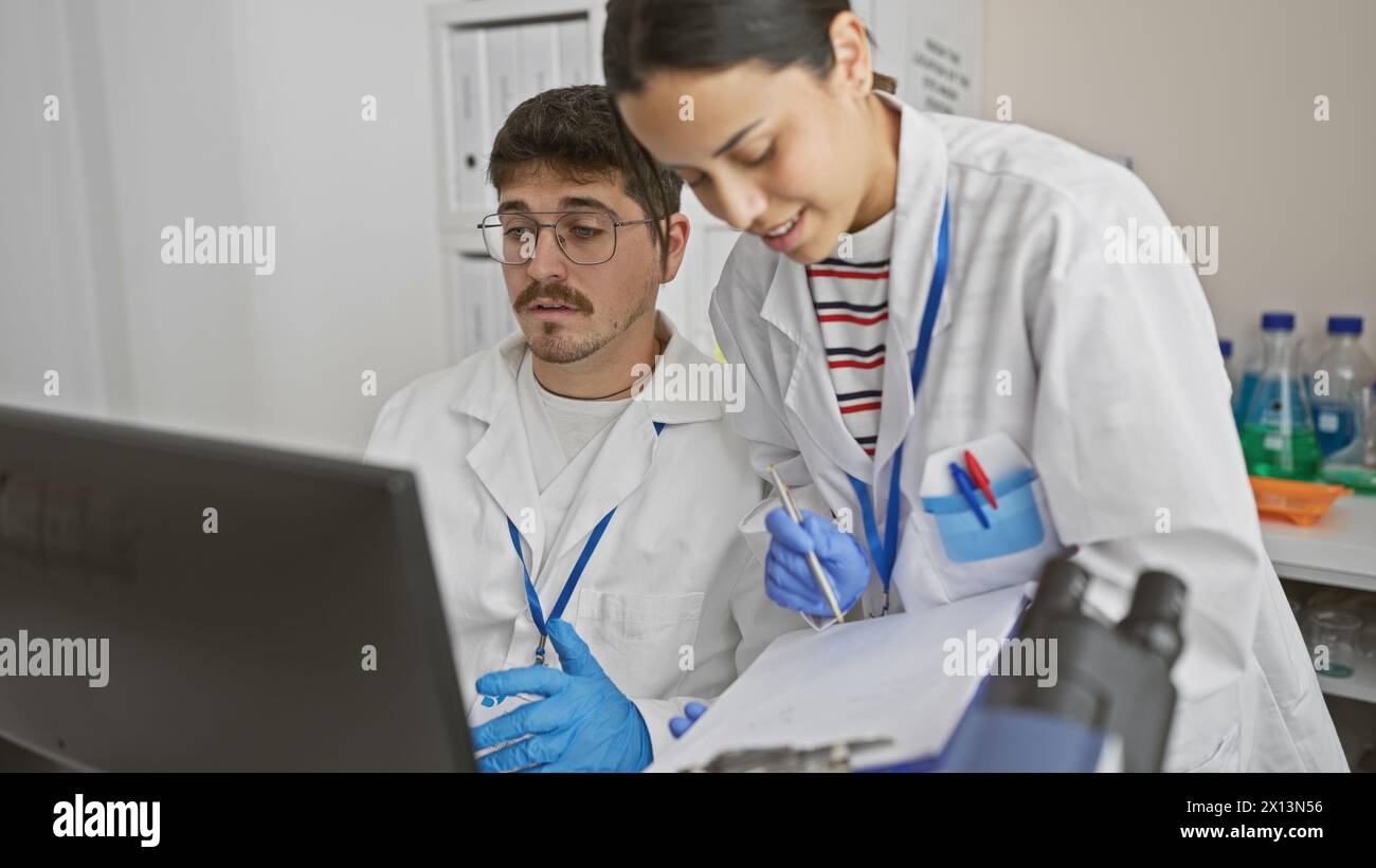 A man and woman are collaborating as scientists in a laboratory ...