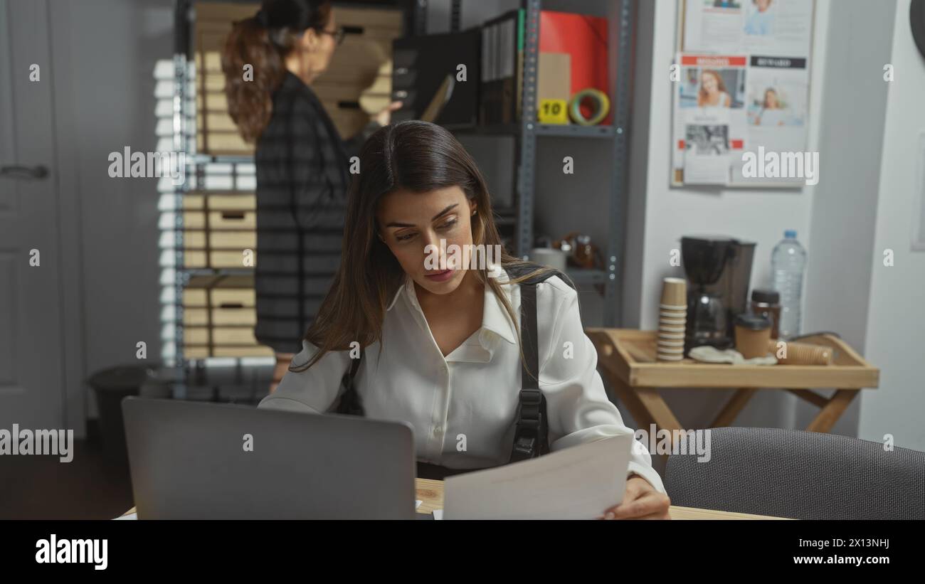 Two women working as detectives in an office, with one using a computer ...