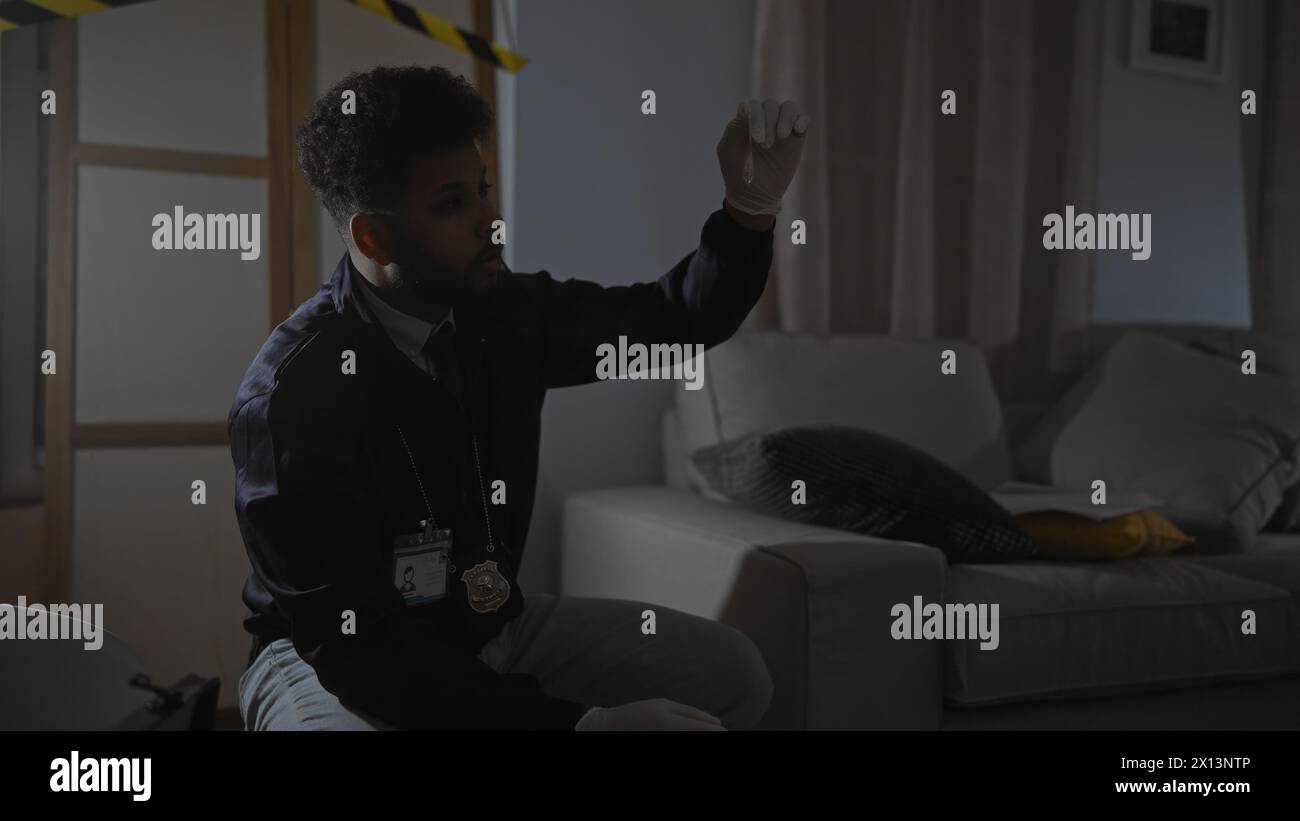 An african american male detective analyzes evidence at an indoor crime ...