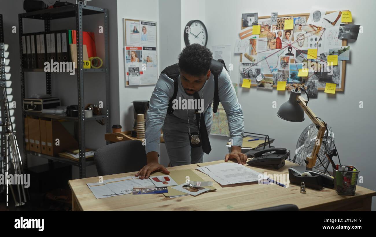 African american detective analyzes evidence in a police office with a ...