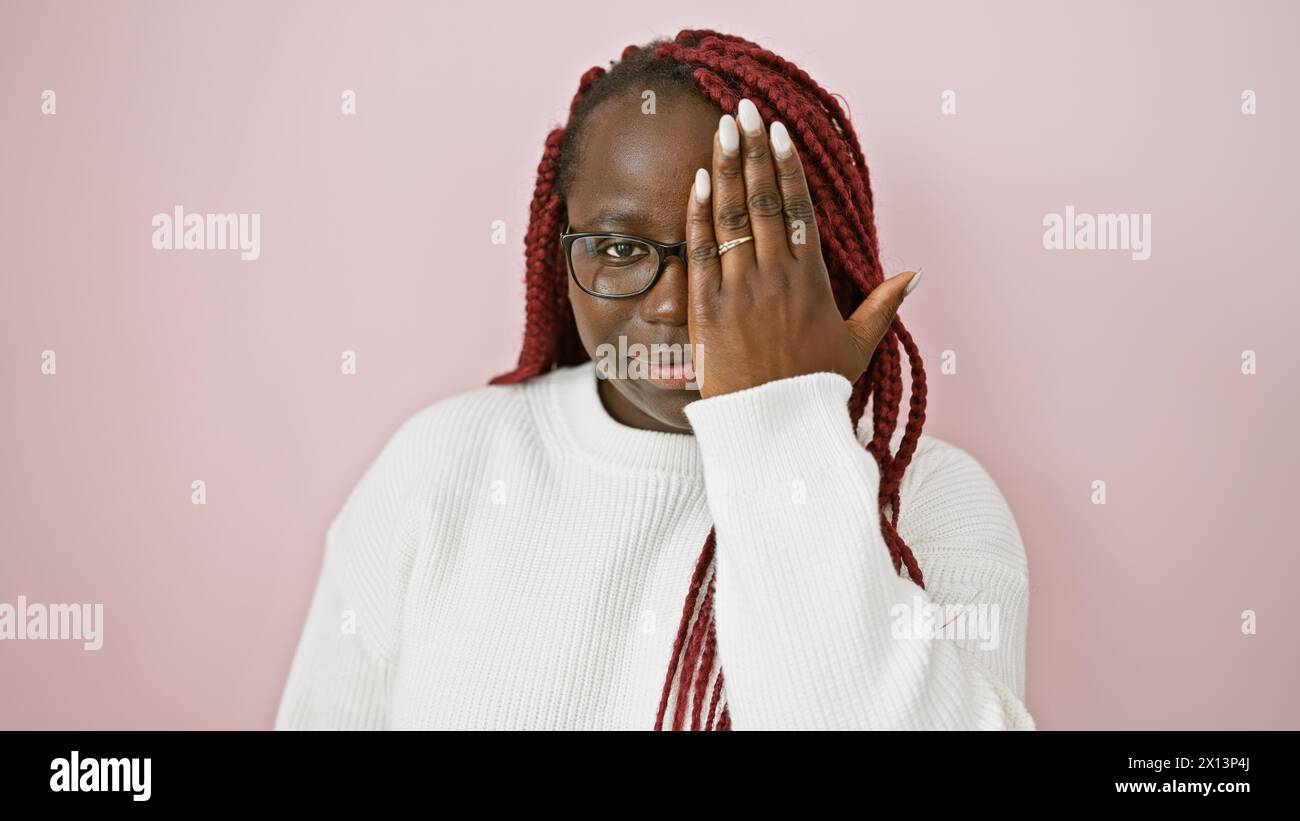 African american woman with braids covering one eye against a pink ...