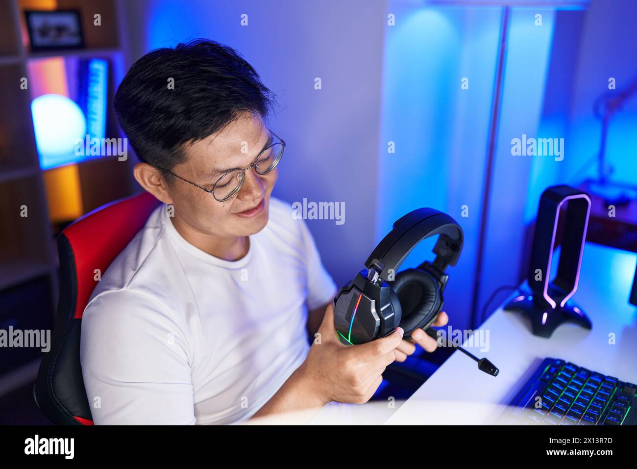 Young chinese man streamer smiling confident holding headphones at ...