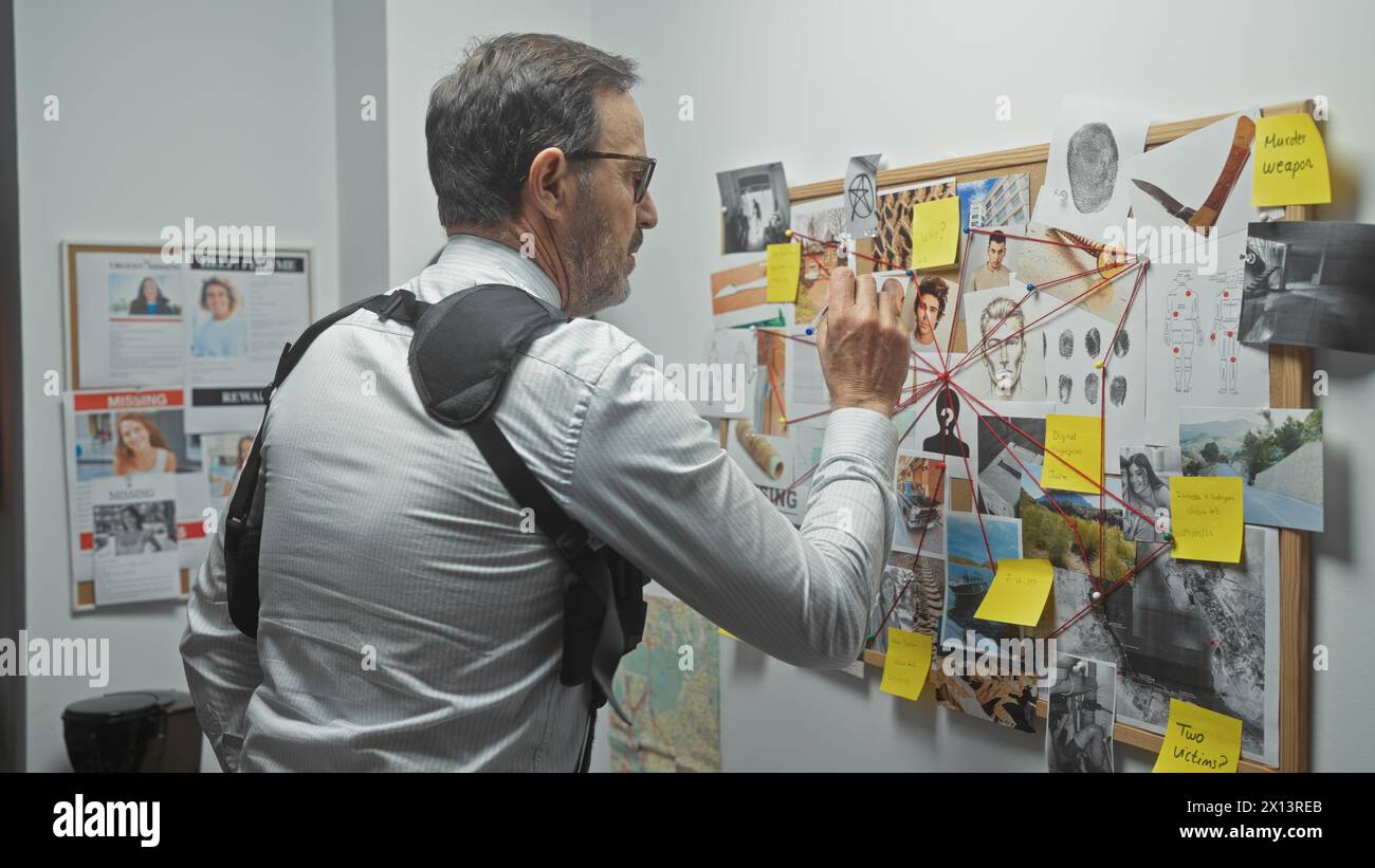 A mature man analyzes a crime evidence board in a detective's office ...