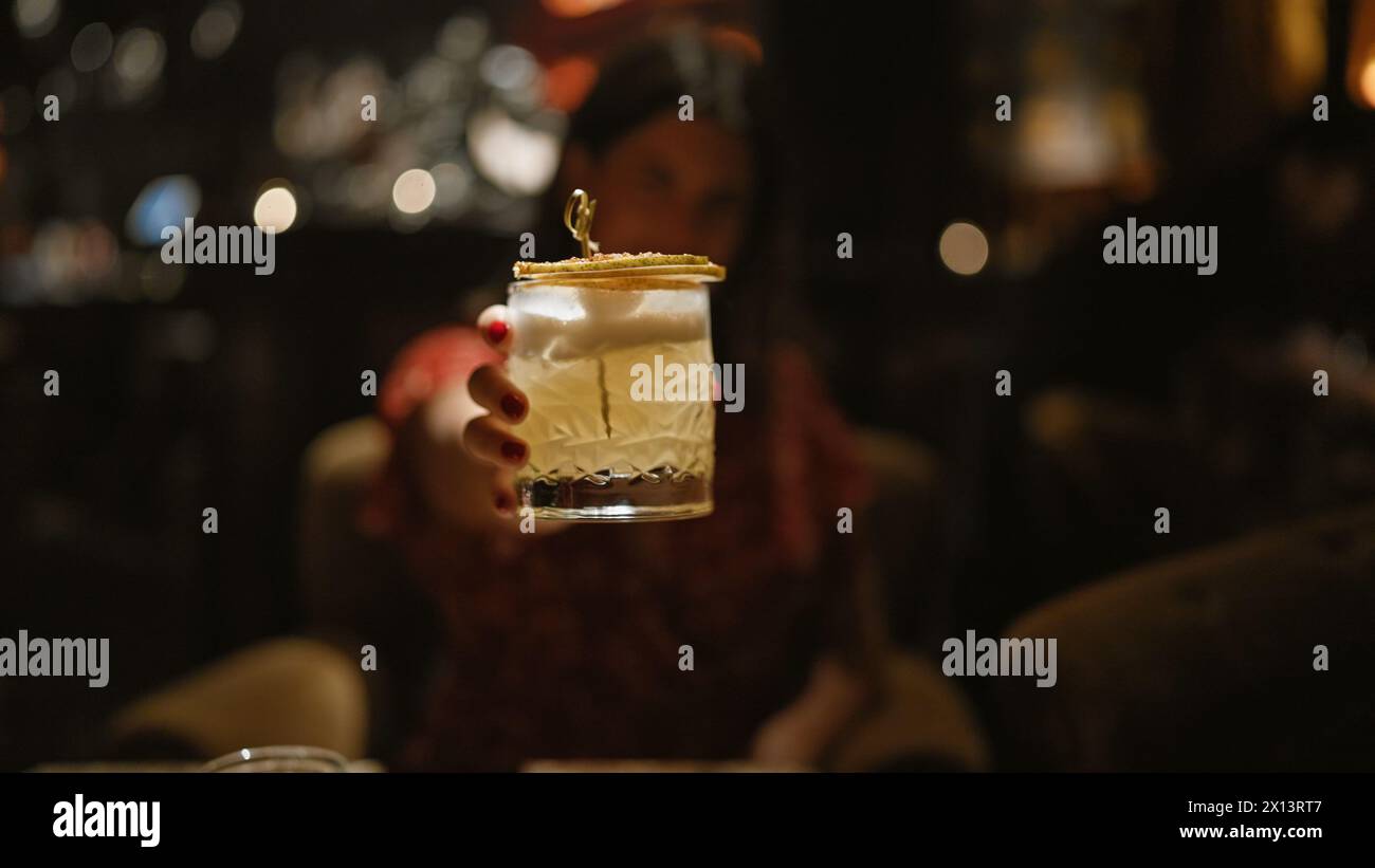 Cheerful, beautiful hispanic woman enjoying a tropical cocktail drink ...