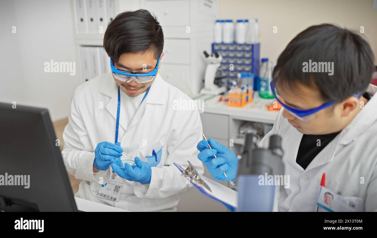Two men in lab coats working attentively in a scientific laboratory ...