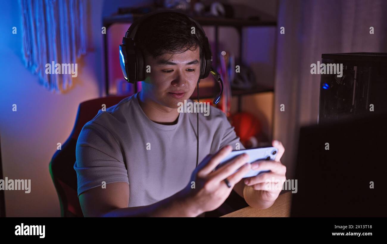 Young asian man gaming at night in a dark room, illuminated by colorful ...