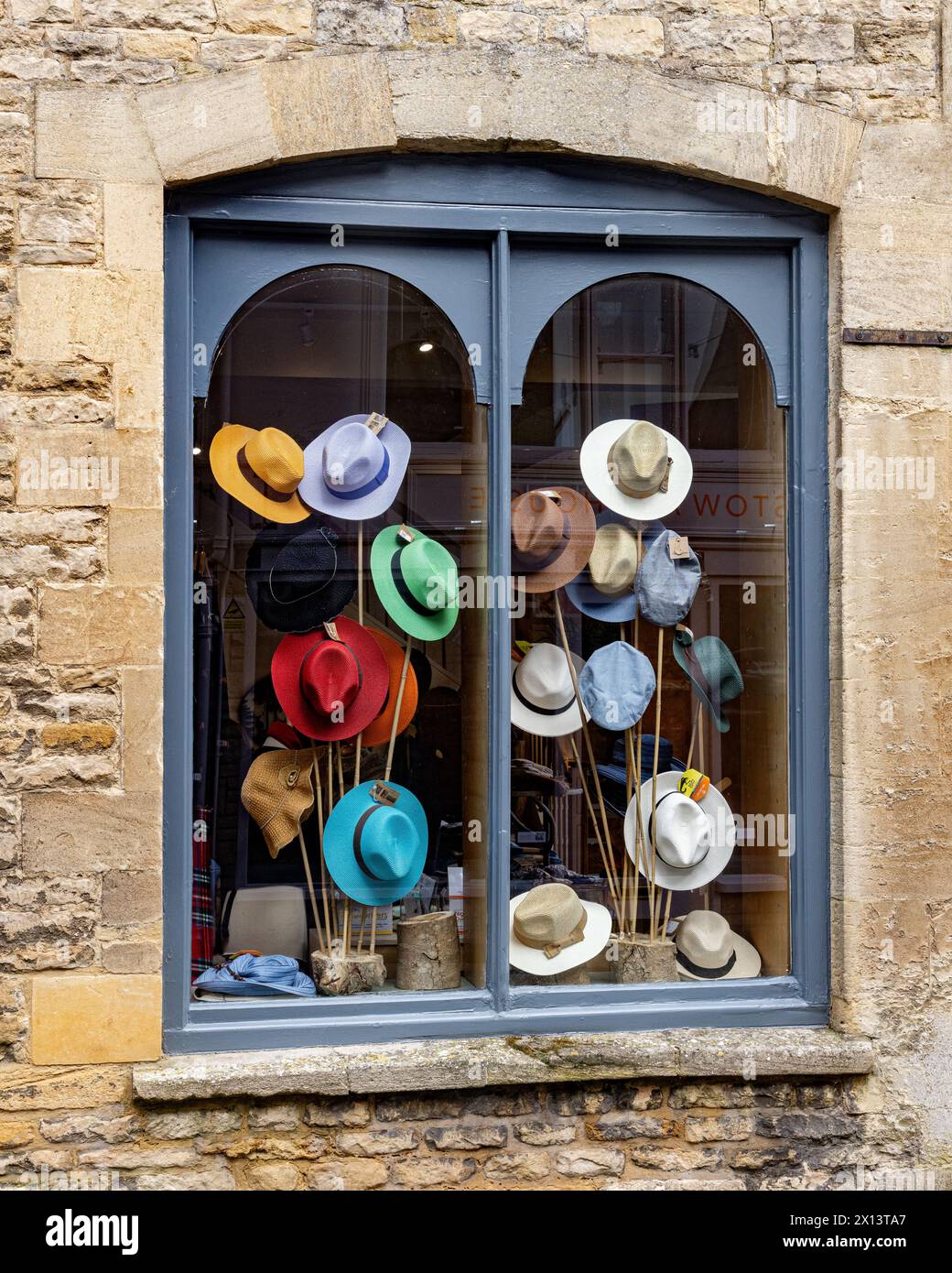 Colorful hats in a Cotswolds shop window, showcasing the charm of this ...