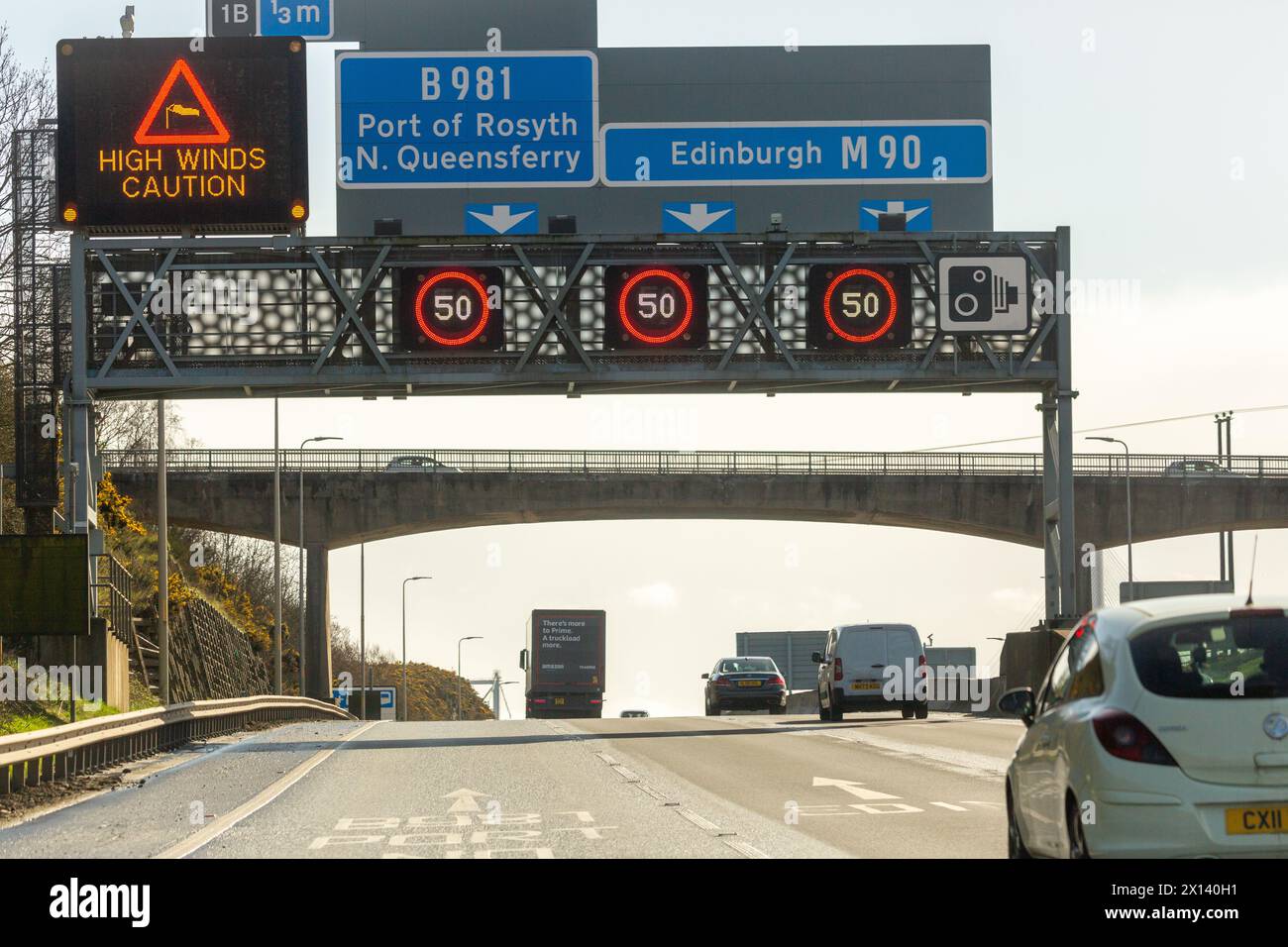 High Winds Caution sign over the M90 Stock Photo - Alamy