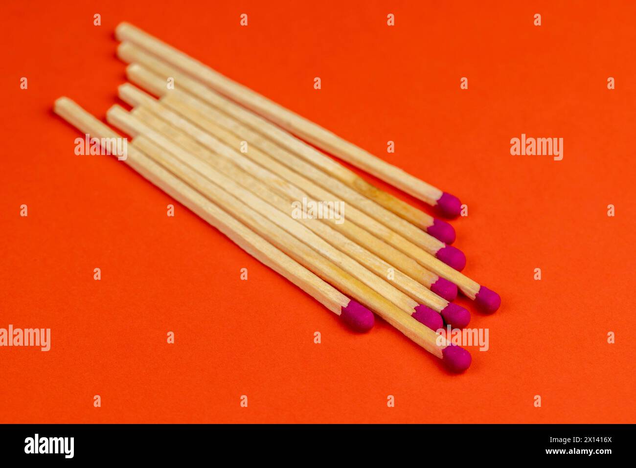 long wooden matches on a paper background, matches with a red pink ...