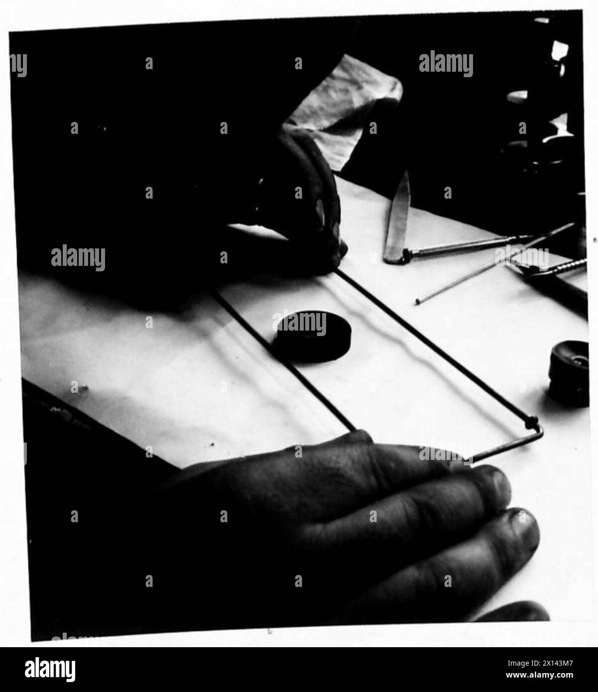 Corporal S. Rogers fits a new spider web to a diaphragm, demonstrating ...