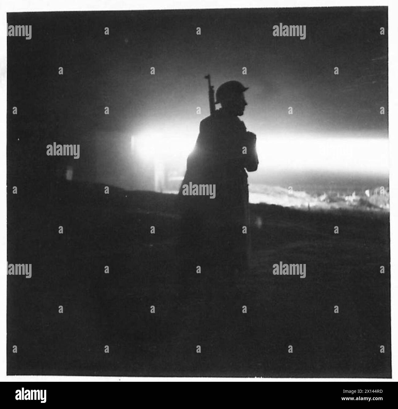 COASTAL DEFENCE ALARM PRACTICE - A sentry on duty on the beach while a ...