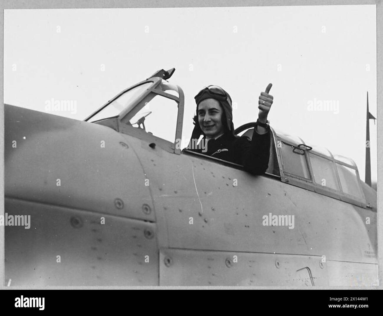 Mary Hooper, a U.S. women pilot of the Air Transport Auxiliary, signals ...