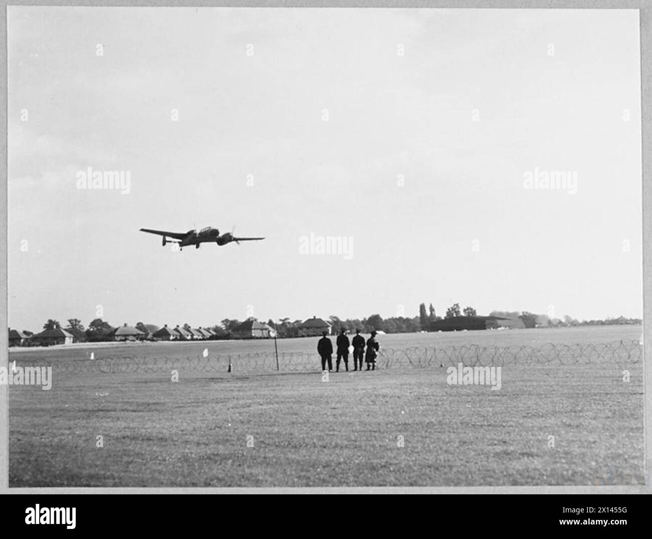 An Me.110 aircraft flies low over an airfield during operations by the ...