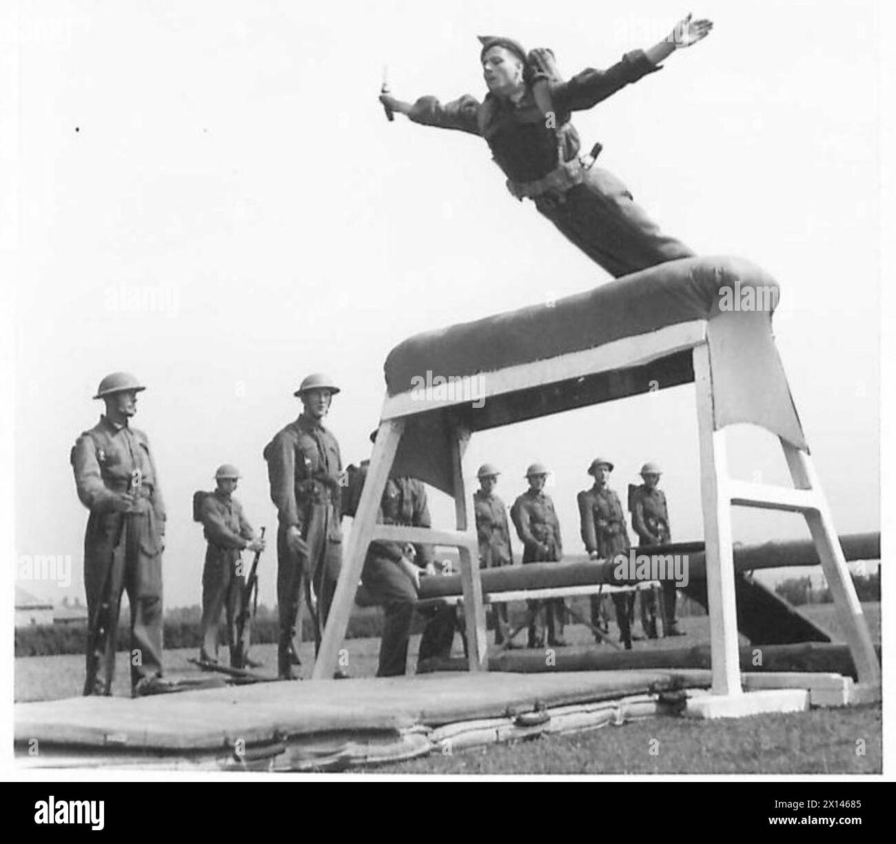 An instructor demonstrates a flying leap over a vaulting horse during ...