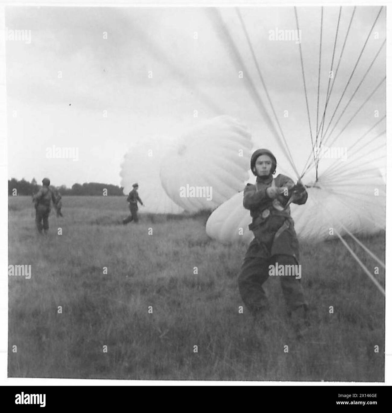 A paratrooper controls his parachute before releasing from the harness ...