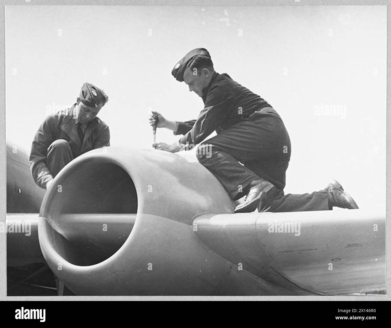 RAF mechanics service a power unit of the 'Meteor' jet aircraft at a ...