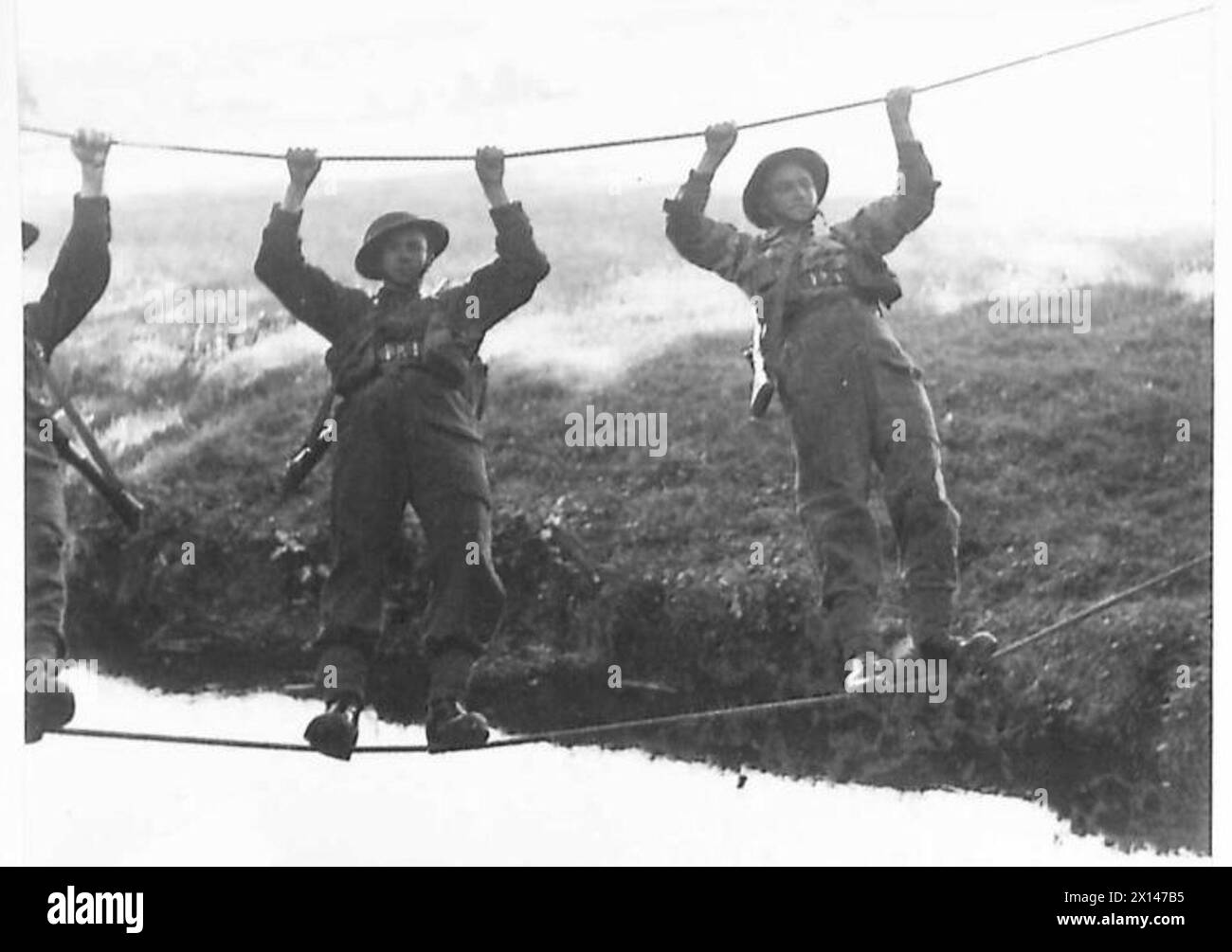 TOUGHENING-UP ON THE ASSAULT COURSE - Troops cross a river by means of ...