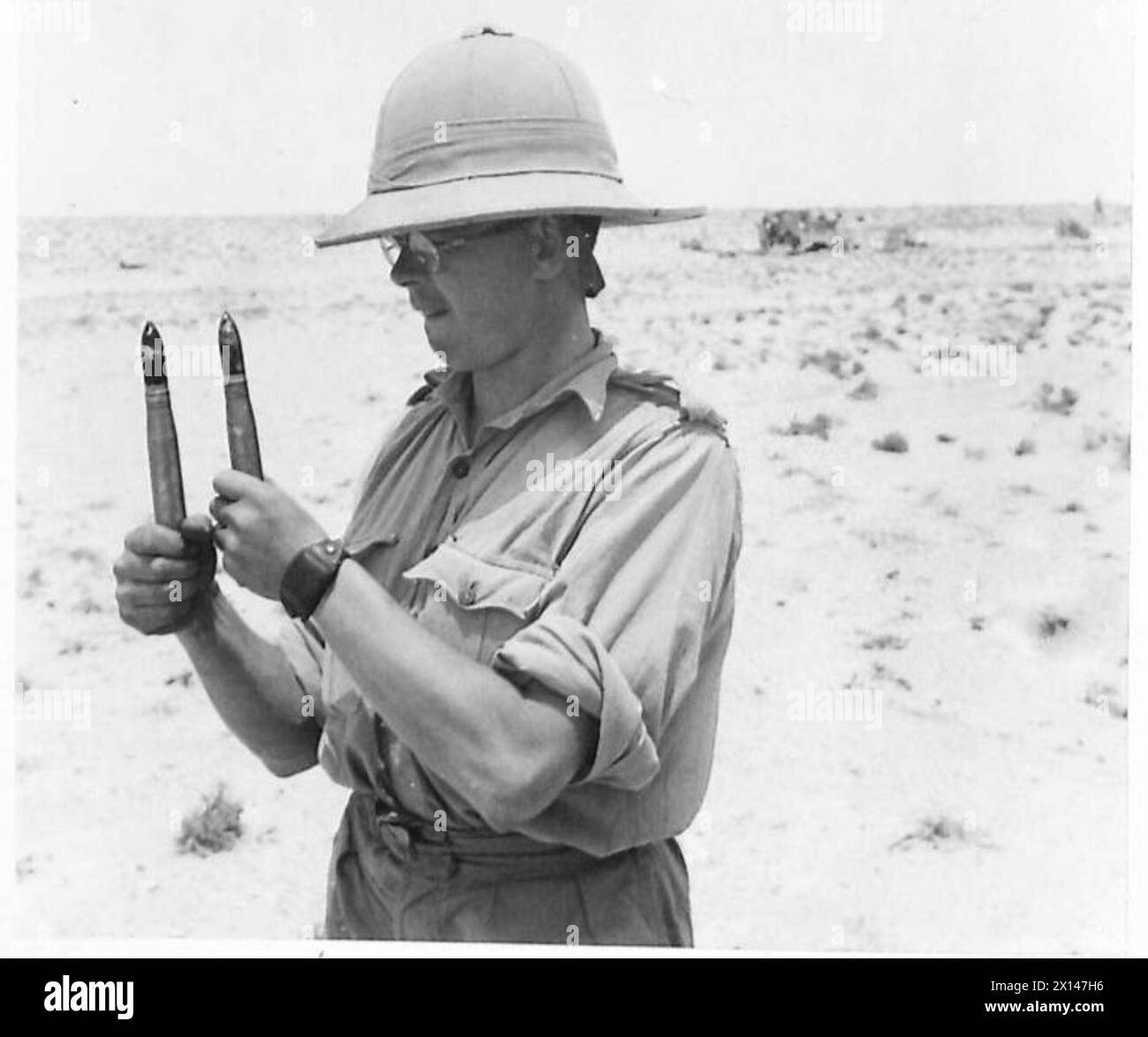 A British soldier examines armour-piercing and high-explosive shells at ...