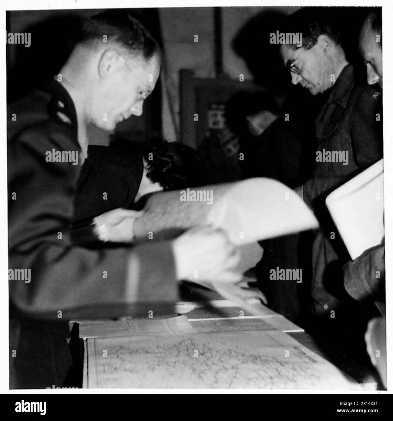 THE INVASION - Correspondents lining up at table for maps showing the ...