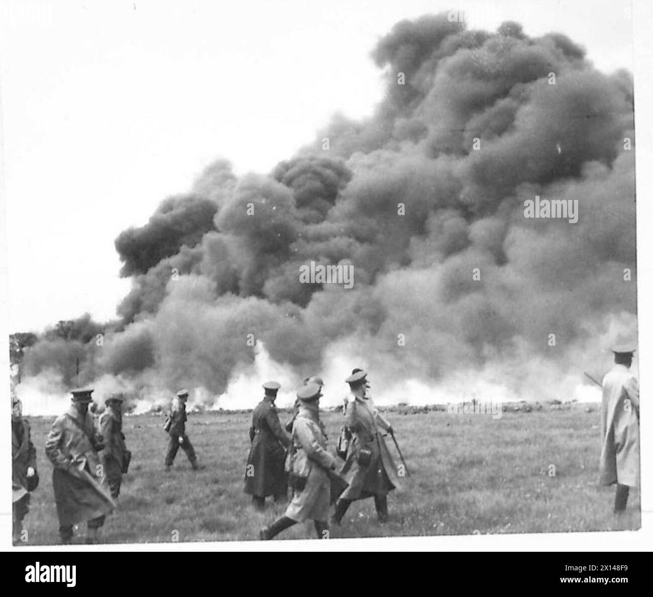 Army officers observe a demonstration of a flame barrage, illustrating ...