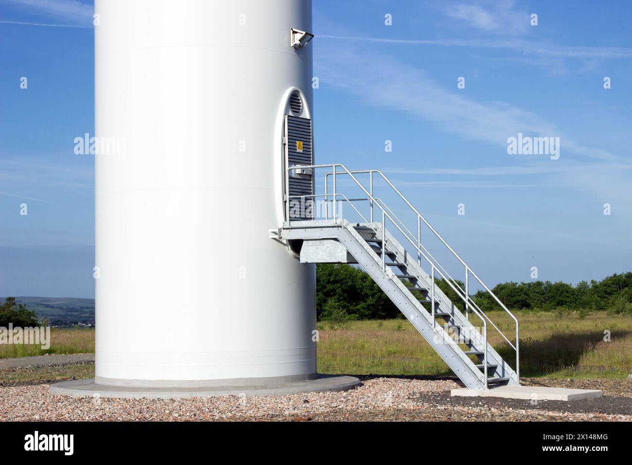 Wind turbine tower and access ladder against blue sky background ...