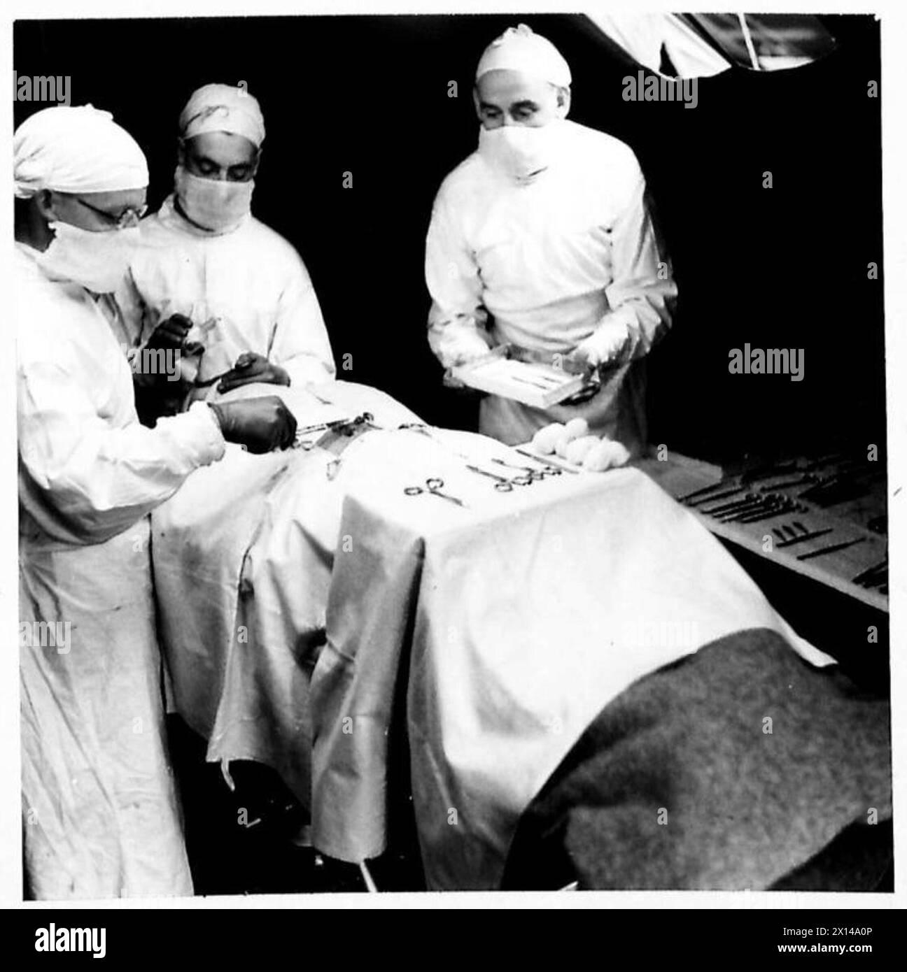 Medical personnel conduct an operation in a tent at an Advanced ...
