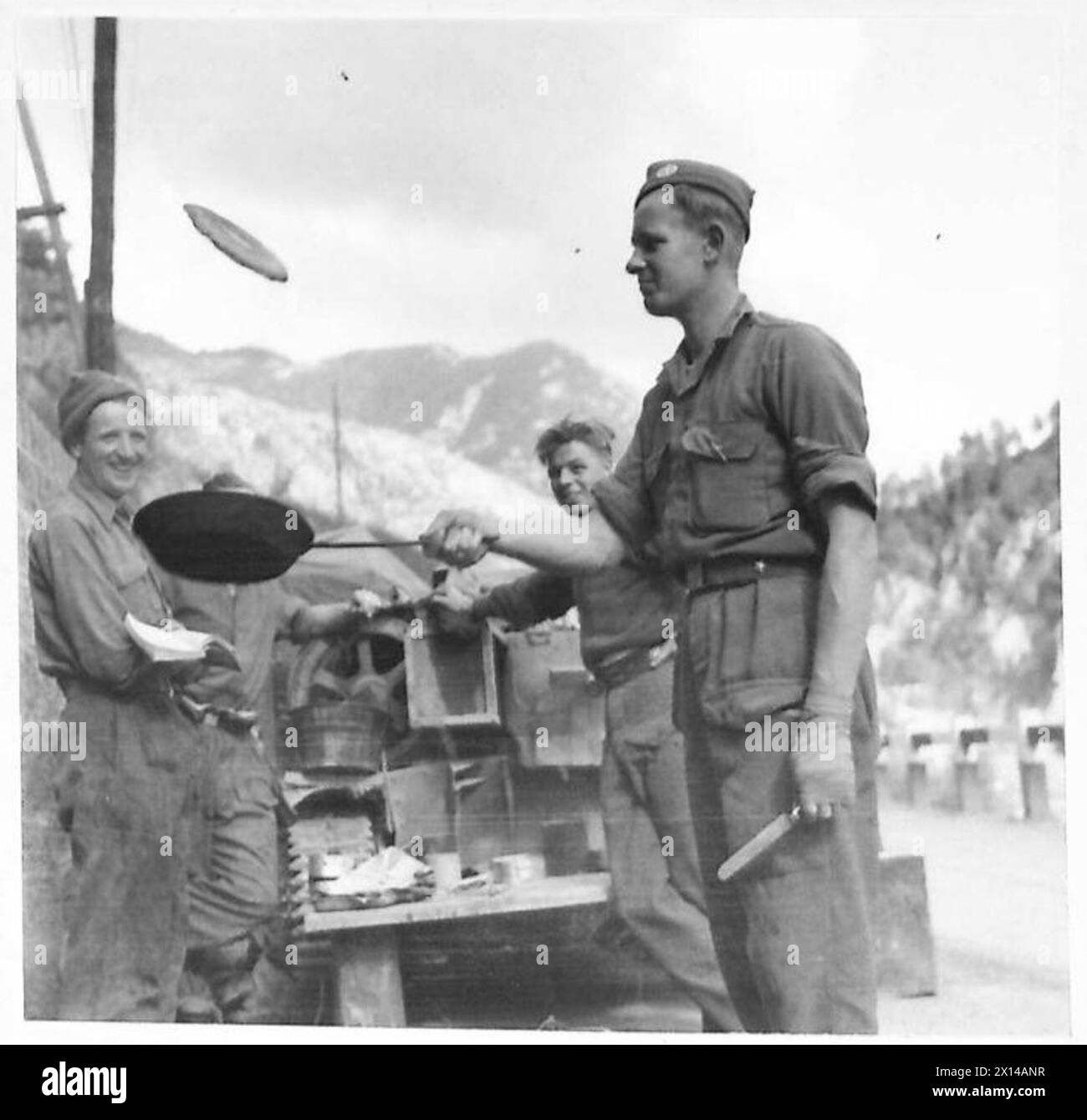 Rfn. R. Heath of Woolwich demonstrates tossing a corned beef pancake to ...
