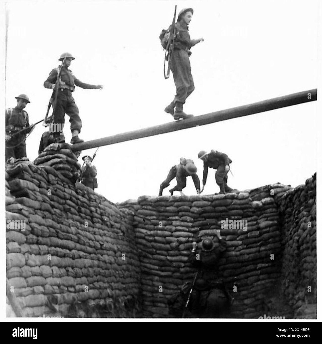 TOUGHENING UP - The men have to walk over a deep trench on a round pole ...