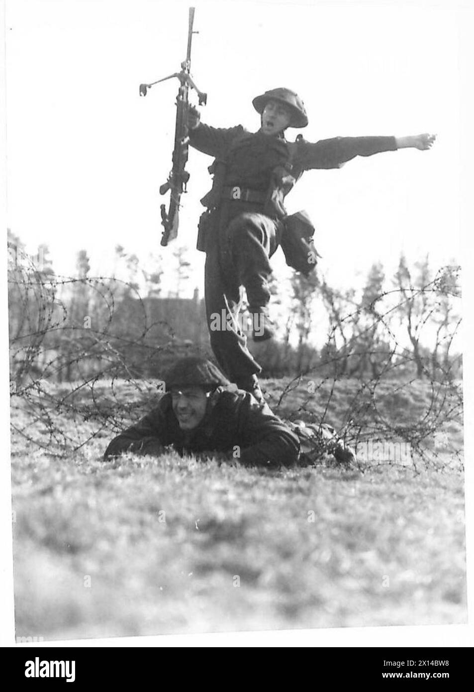Commandos in training practice crossing barbed wire obstacles by using ...