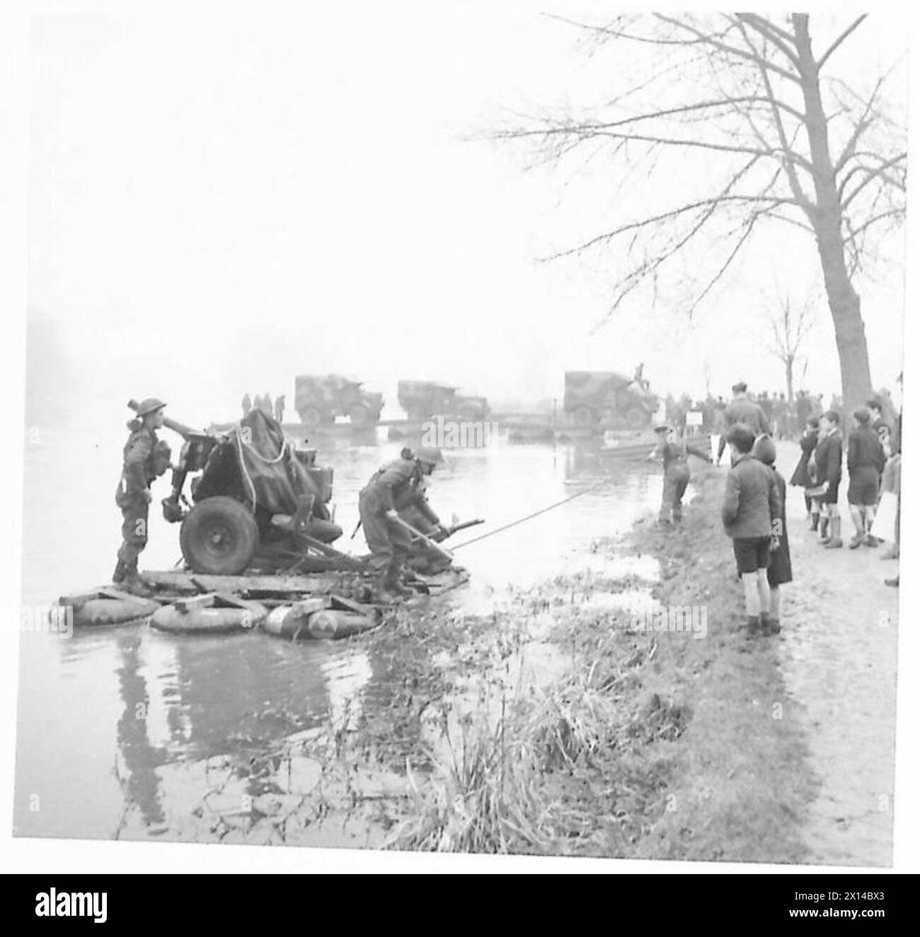 An anti-tank gun is ferried across the Thames on a raft made from small ...