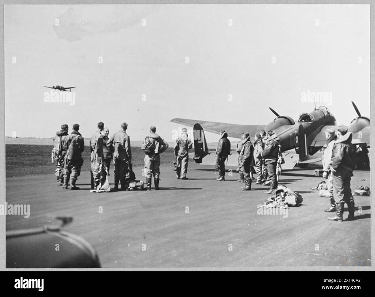 Pilots of raiding aircraft wait at an RAF airfield for the return of ...