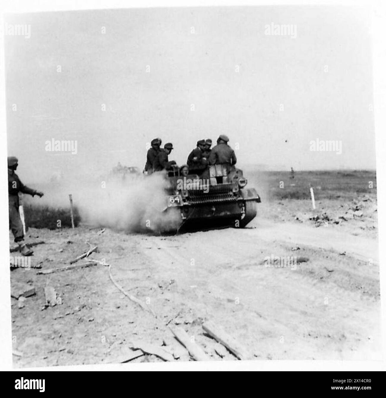 A military carrier carrying German prisoners travels along a dusty road ...