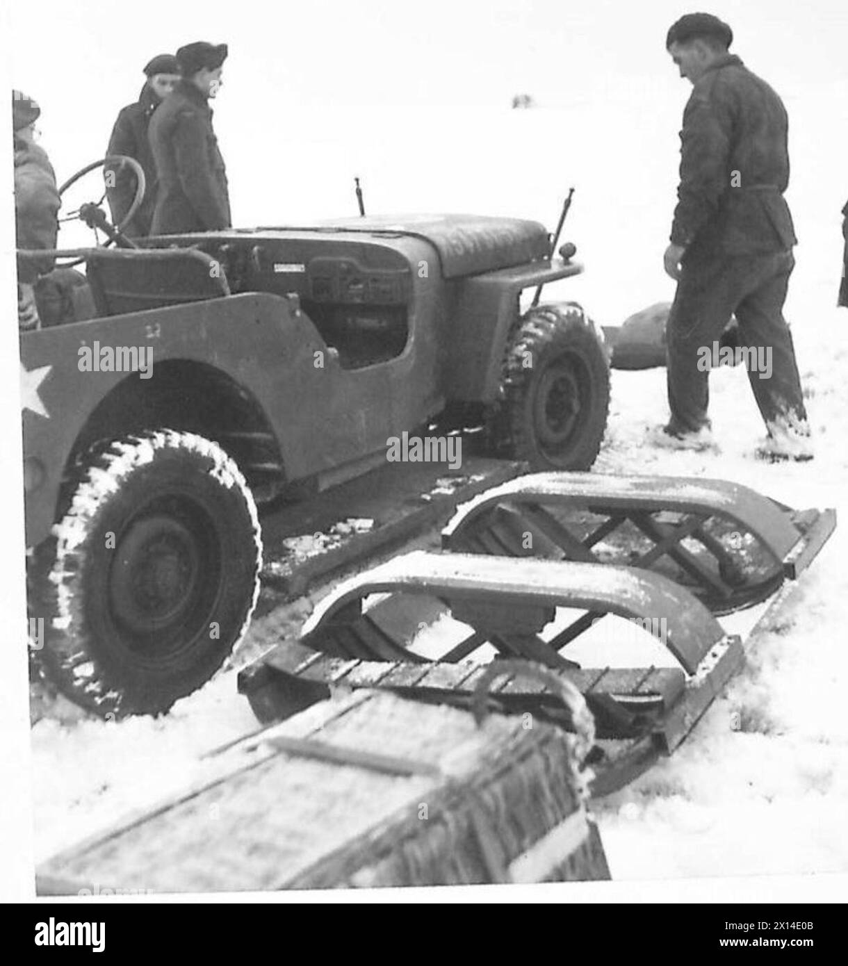 A jeep dropped by parachute is examined by officers on the ground in an ...