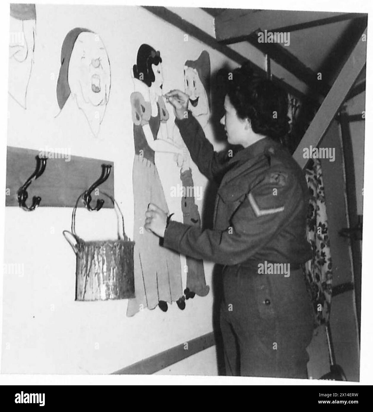 Lance Corporal Grace Golland of the A.T.S. decorates her sleeping hut ...