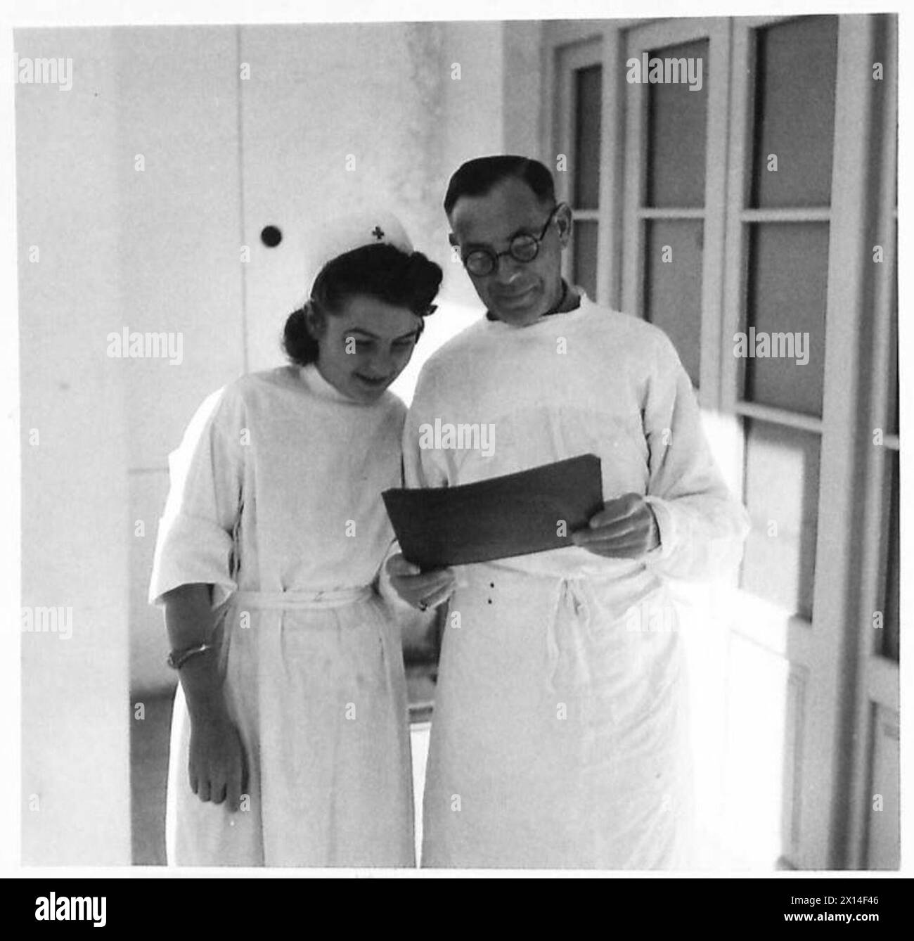 Dr Reznikov and Sister Jadwiga Reszczyńska examine an X-ray at the ...