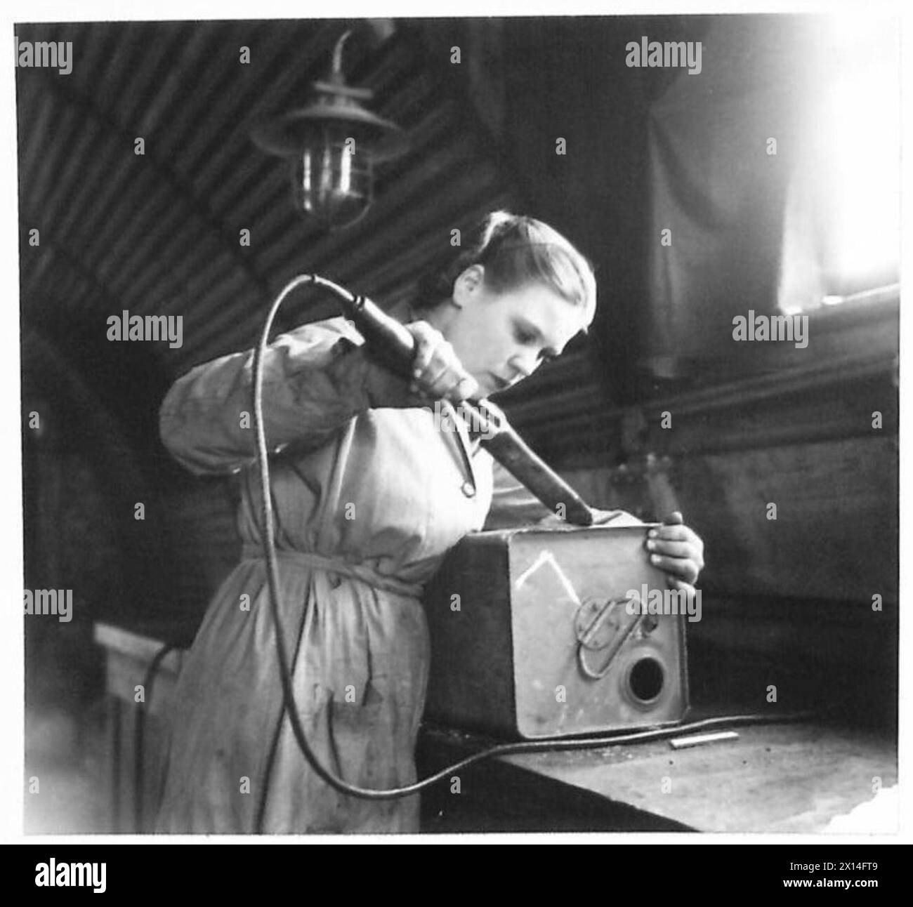 An ATS girl repairs a leaking fuel can using a soldiering iron at the ...