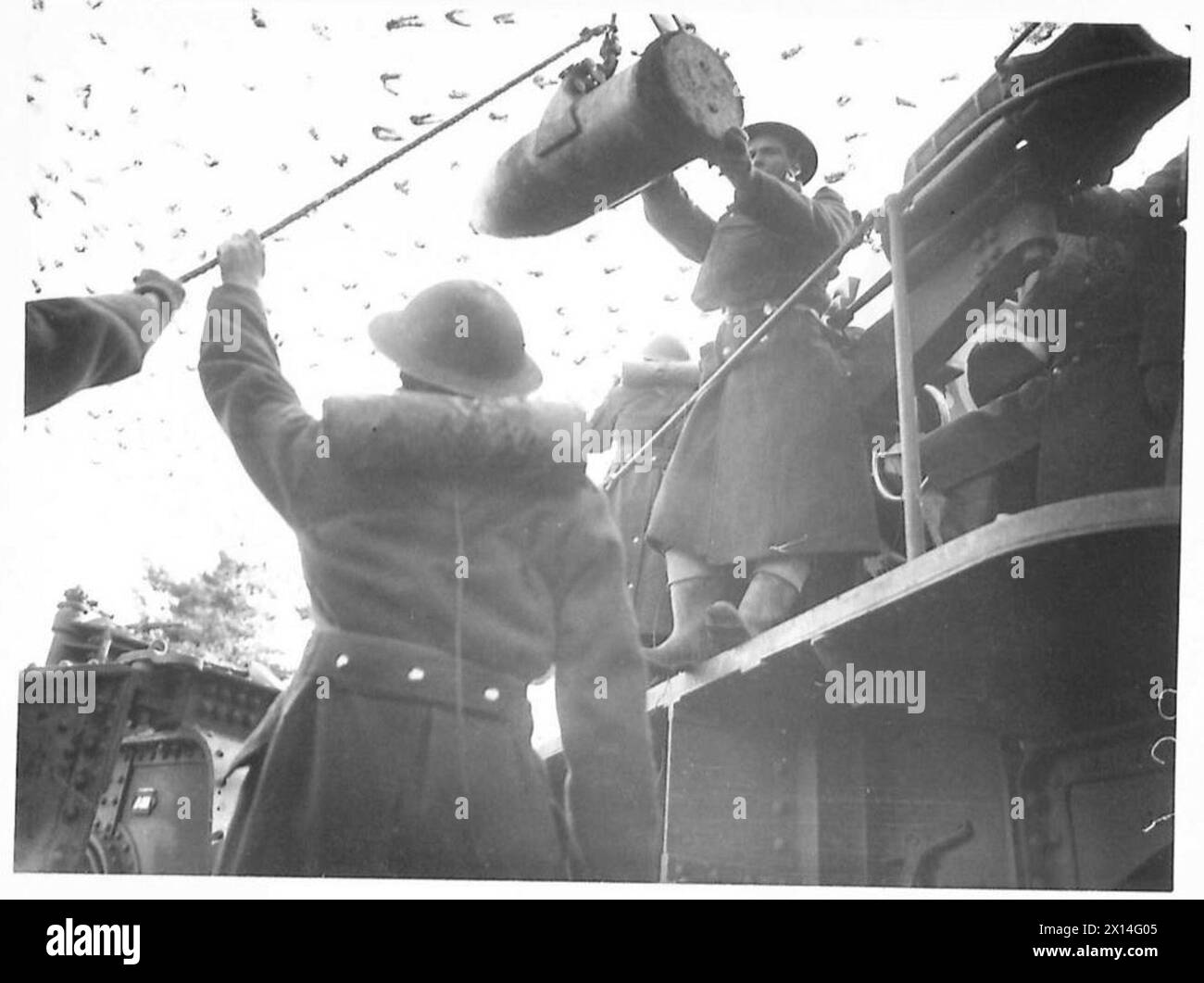 ONE OF BRITAIN'S TEETH - A shell being hoisted on to the loading cradle ...
