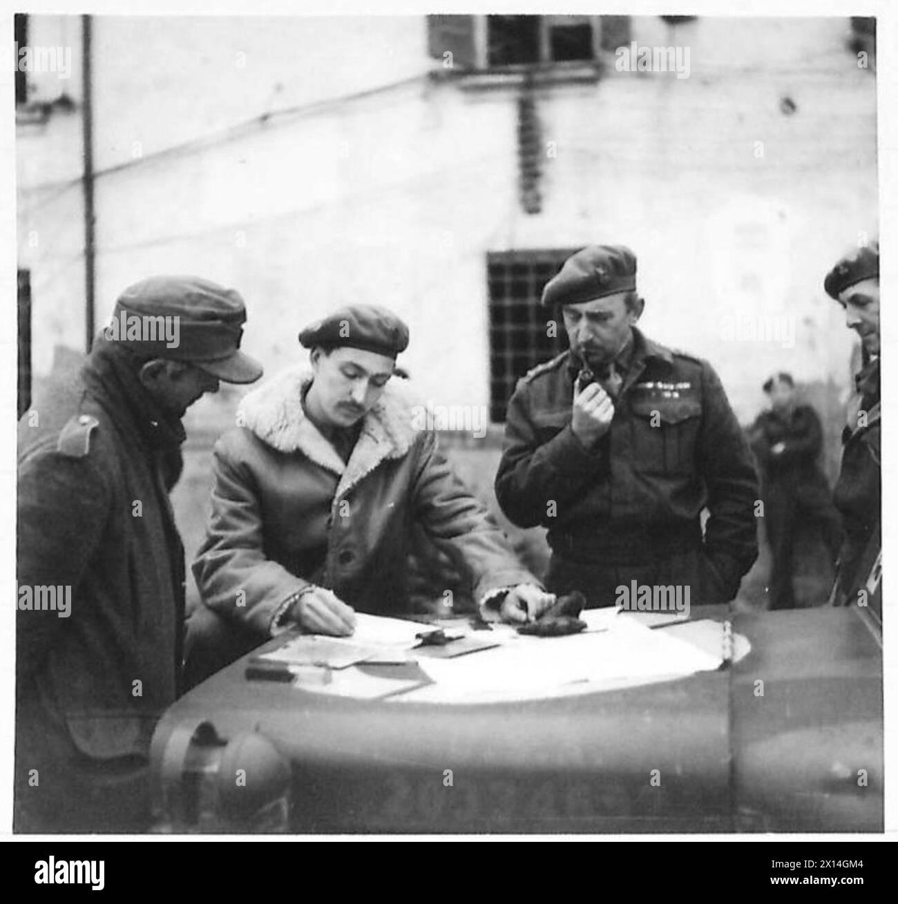 EIGHTH ARMY : INTERROGATION OF GERMAN P.O.W. - Brigadier Barker, OBE., MC., looks on as Lieut ...