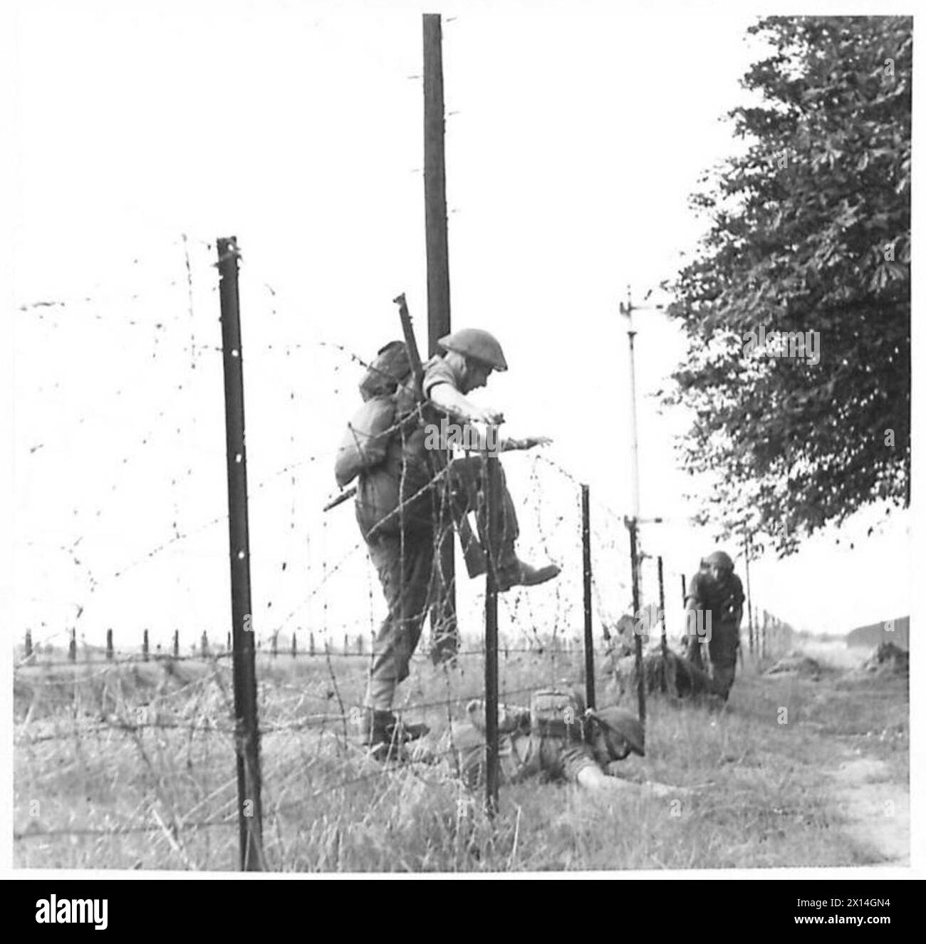 BATTLE SCHOOL EXERCISE - Troops negotiating barbed wire fence British ...