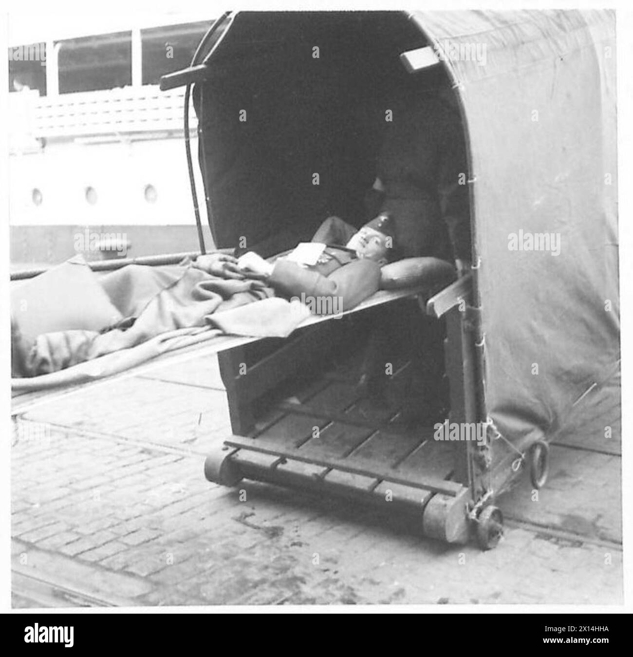 A wounded German airman is transported aboard a vessel on a stretcher ...