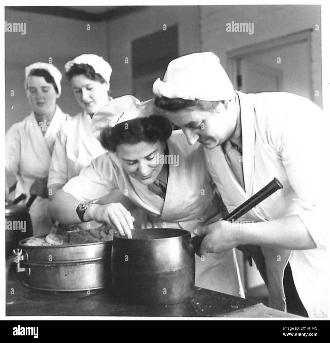 At the ATS School of Cookery, the Sergeant Major instructor closely ...